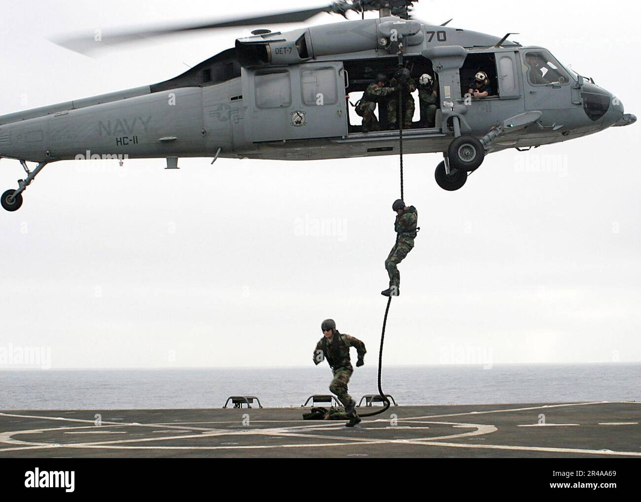 US Navy Explosive Ordnance Disposal (EOD) members repel from an MH-60S Knighthawk Stock Photo ...