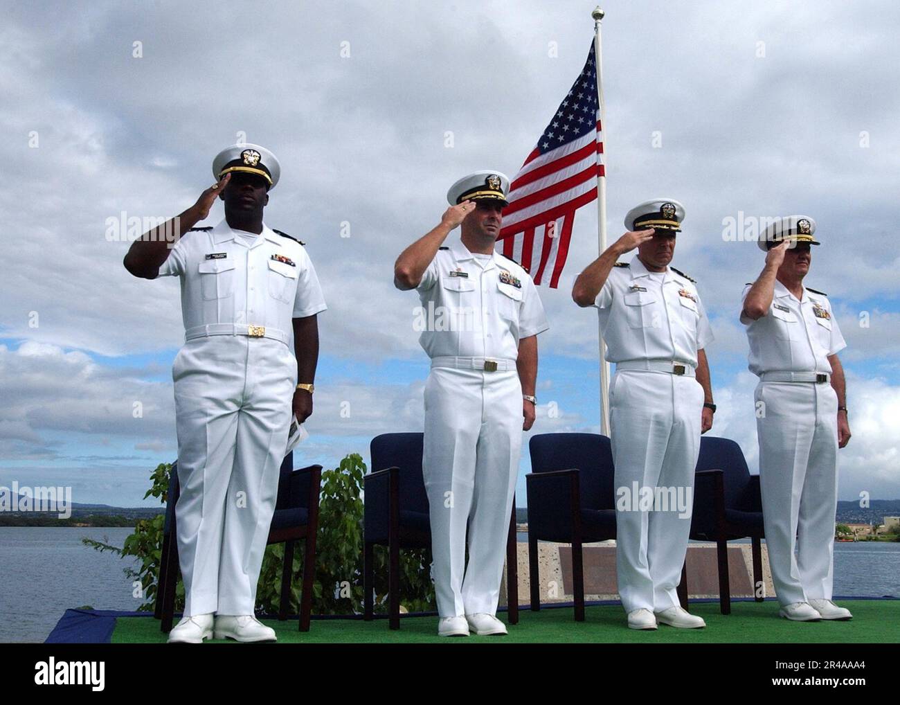 US Navy Members of the official party salute in front of the USS Nevada ...