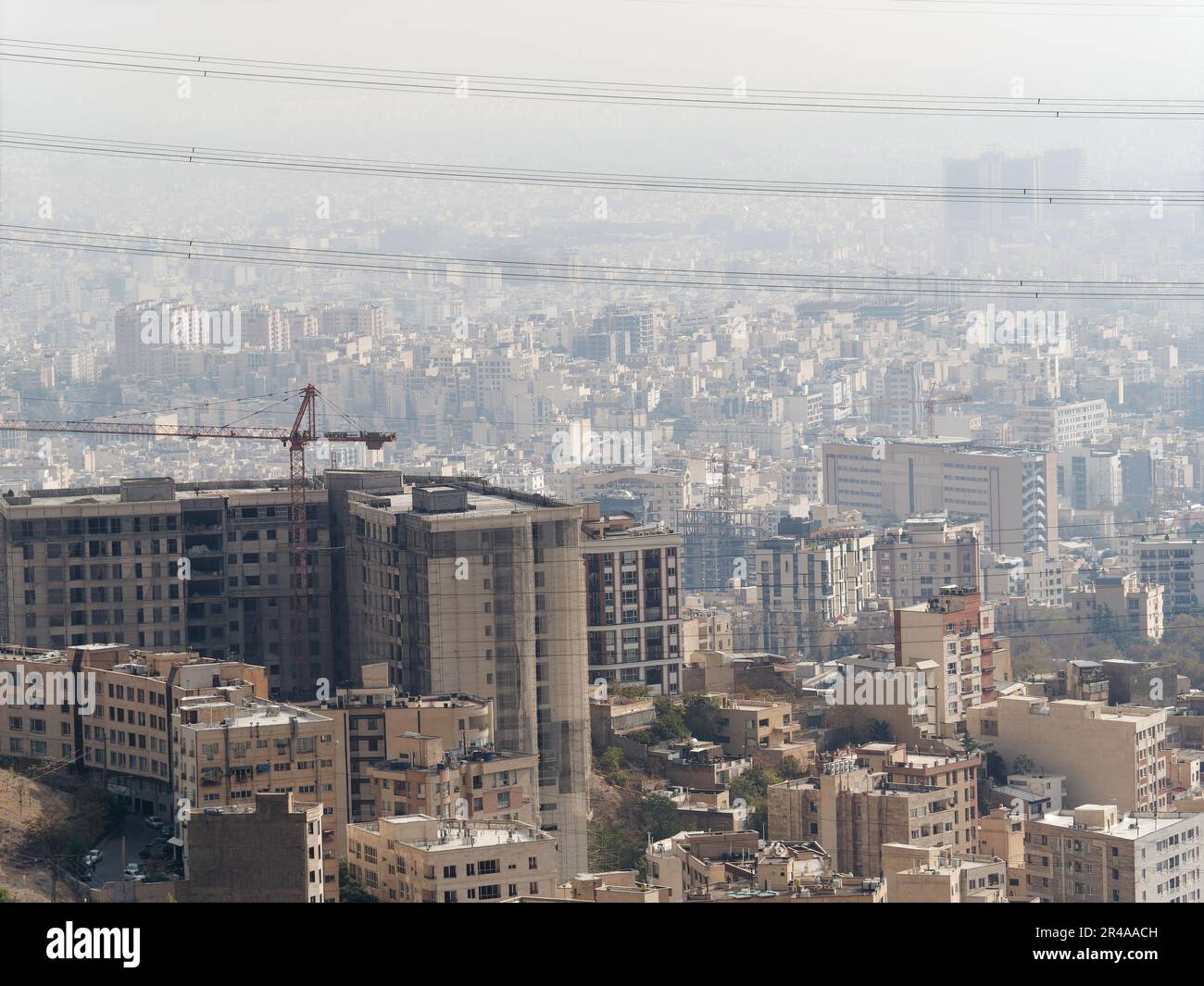 An aerial cityscape view of Tehran with multiple power lines ...