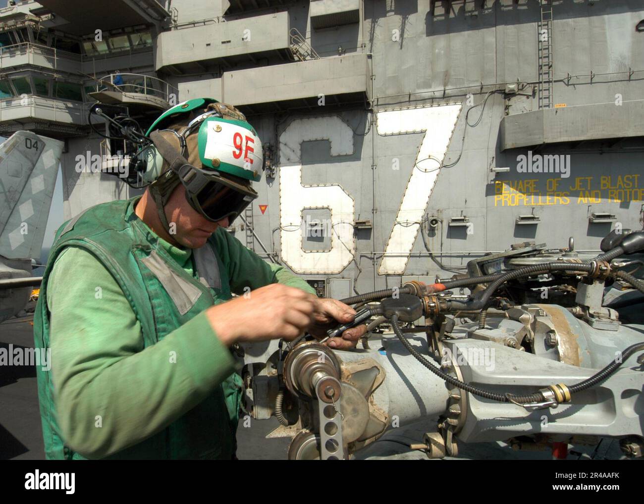 US Navy An Aviation Machinist Mate performs maintenance on the main ...