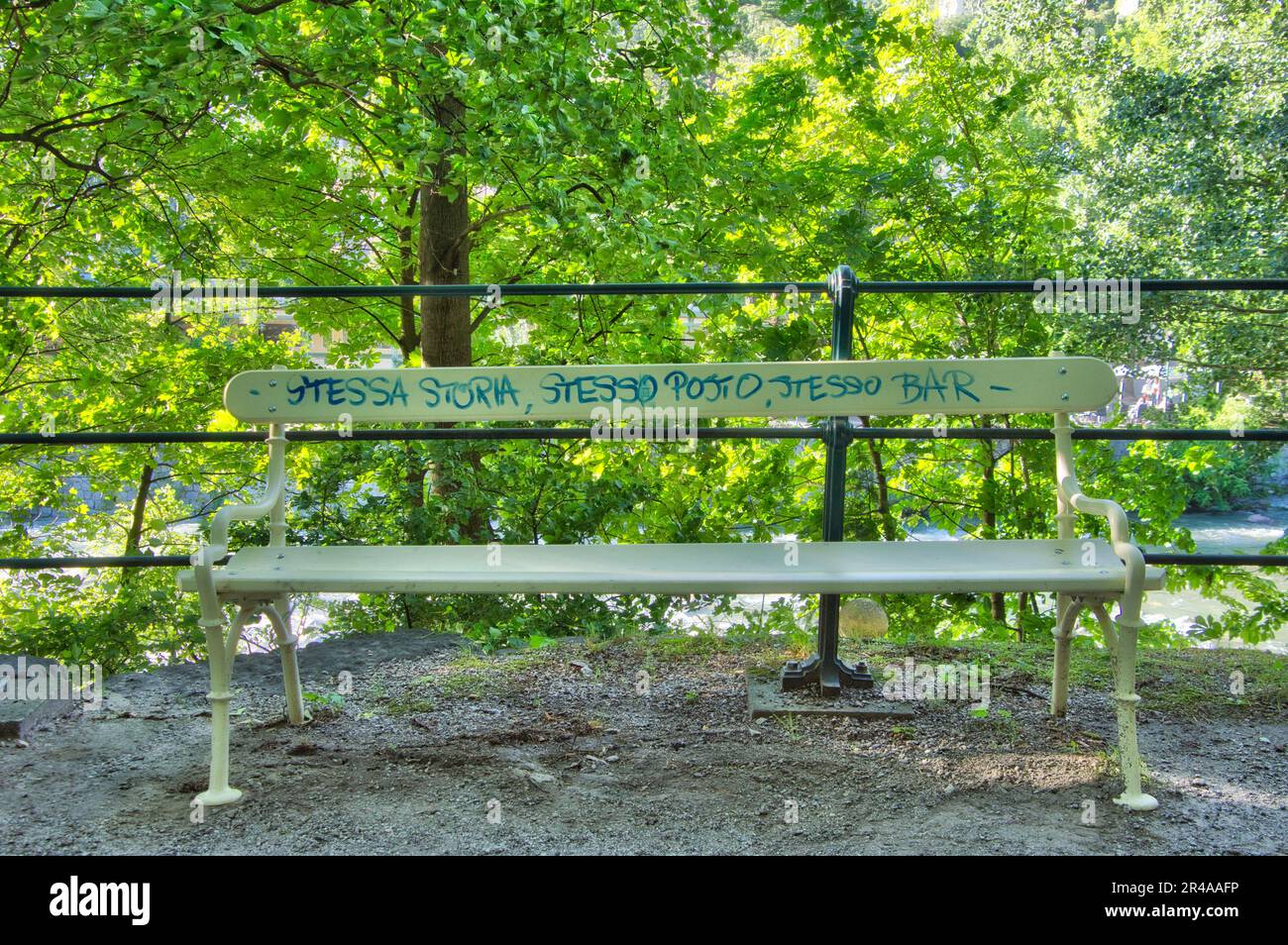 A wooden park bench with a phrase that reads "SAME STORY, SAME PLACE ...
