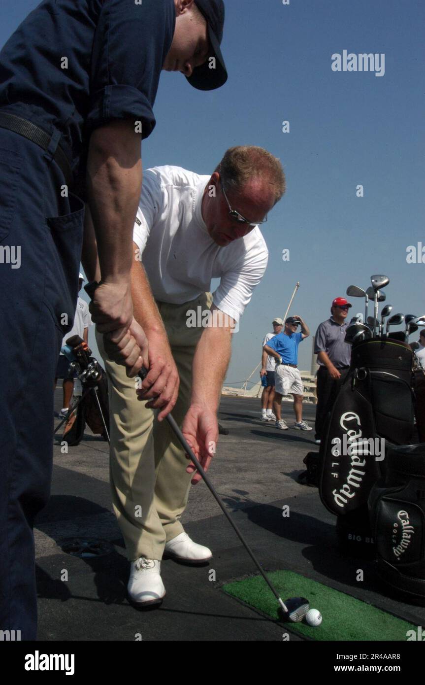 US Navy A Golf Pro from Callaway Golf assists a Sailor on his golf ...