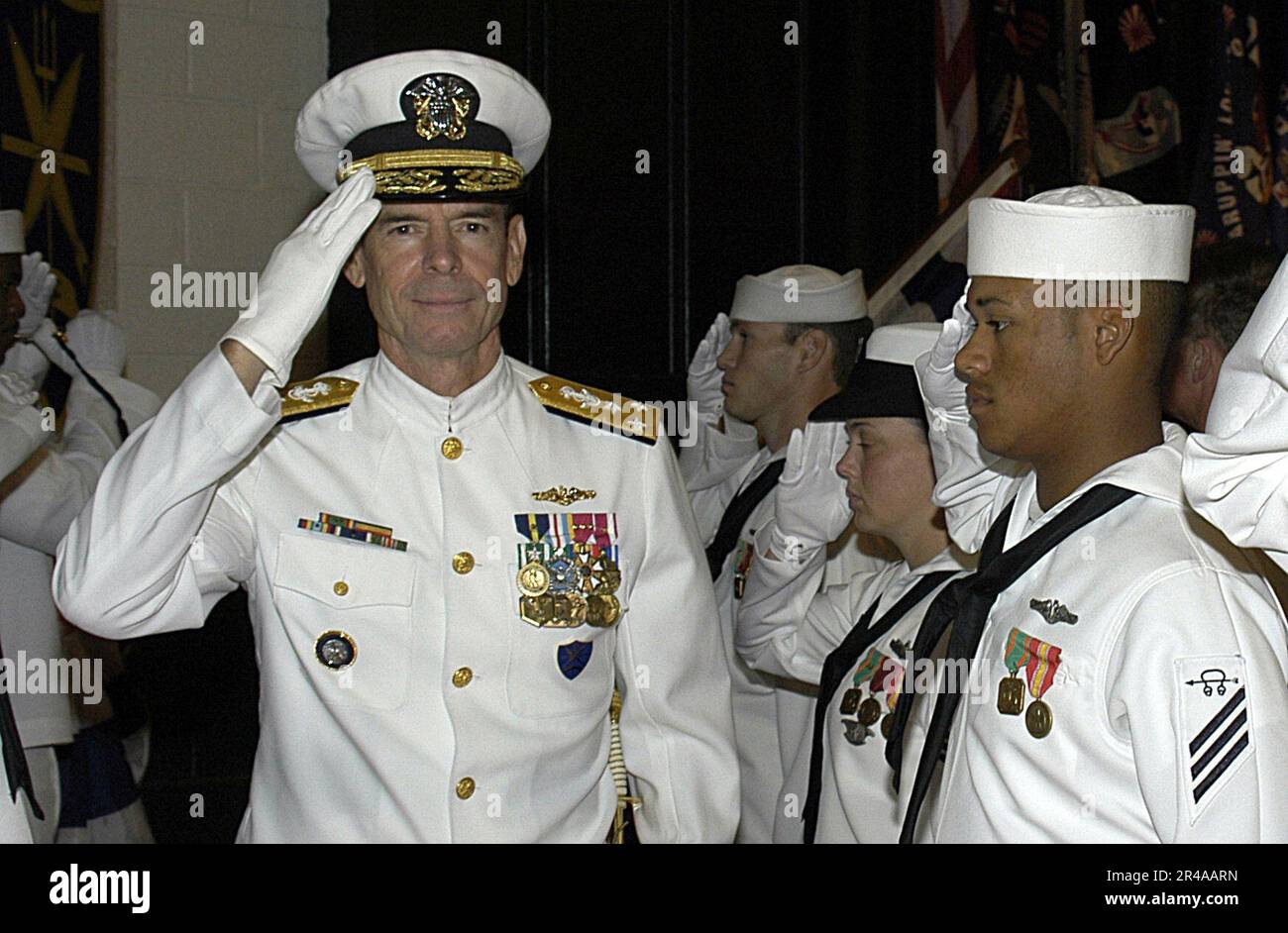 US Navy Vice Adm. Charles L. Munns salutes as he passes through side ...