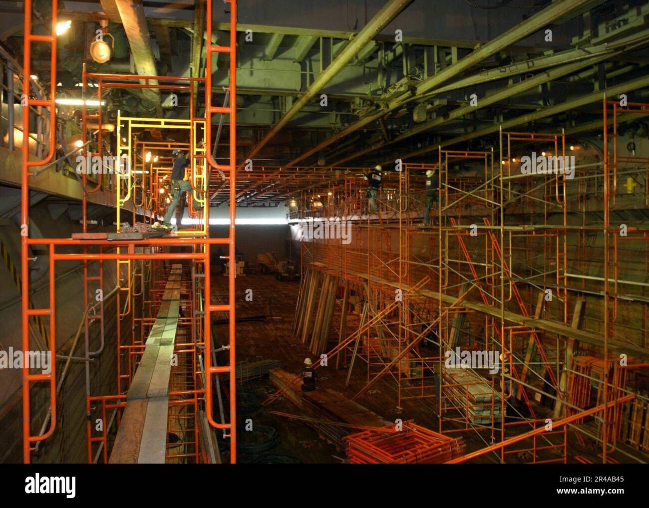US Navy Civilian contractors make repairs inside the well deck aboard ...