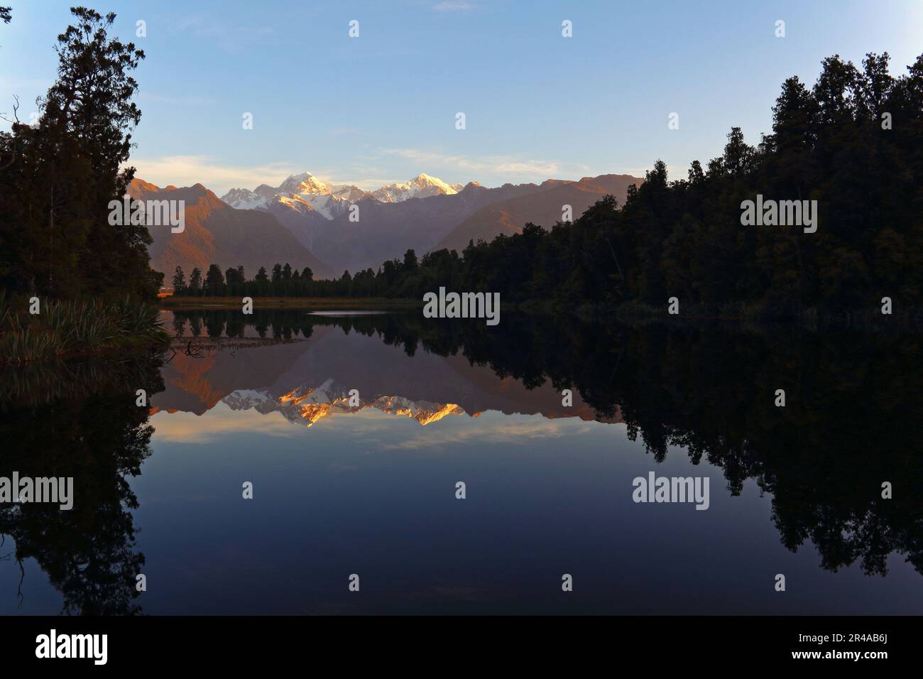 A majestic sunset at Lake Matheson with a reflection of Mount Cook and ...