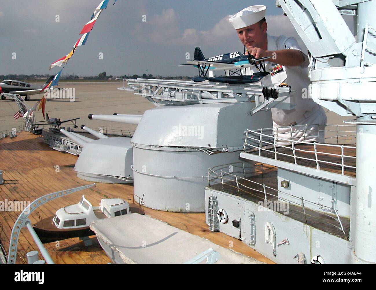 US Navy Engineman 1st Class adjusts a model of OS2U Kingfisher seaplane ...
