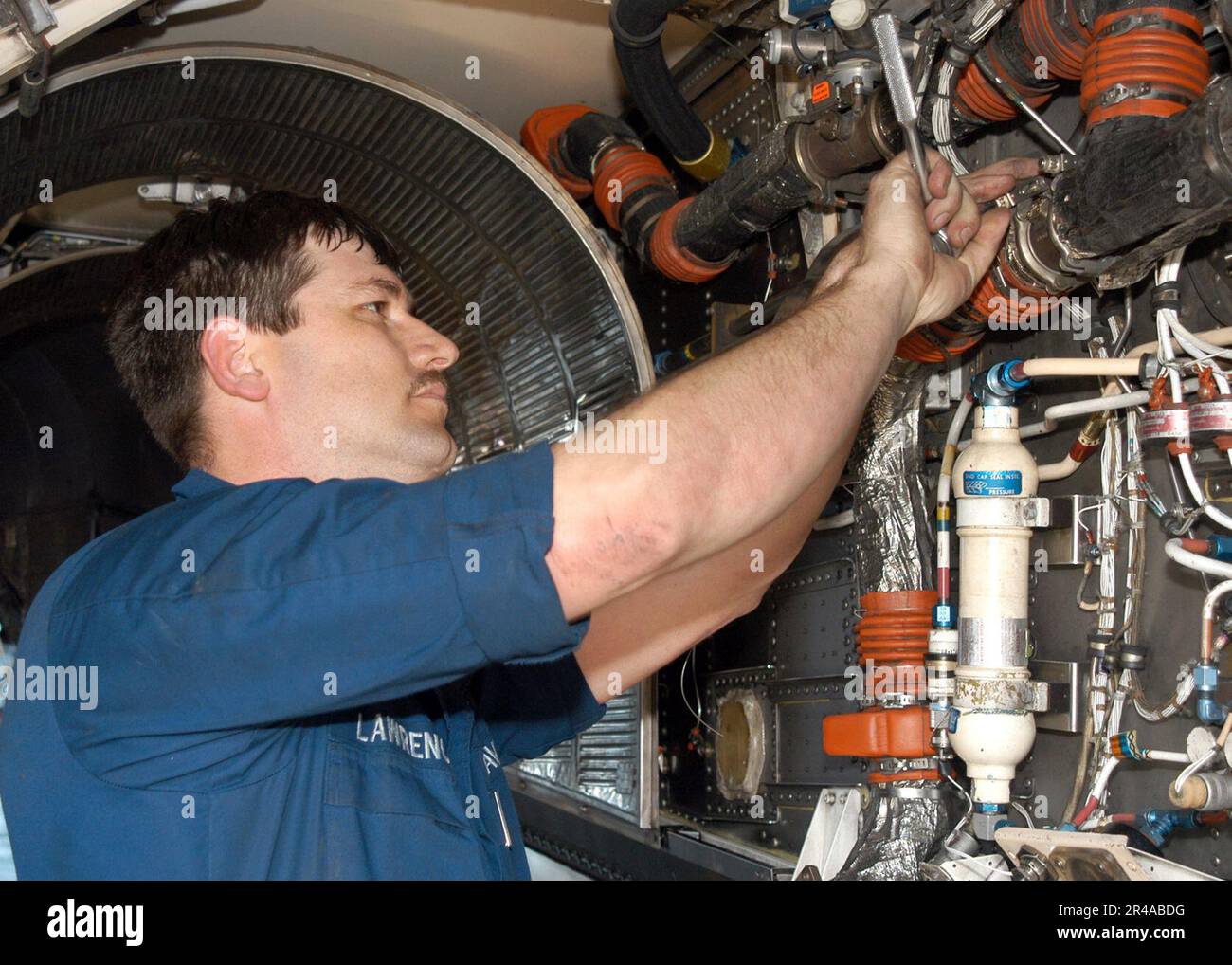 US Navy Aviation Machinist's Mate 1st Class works to fix a check valve ...