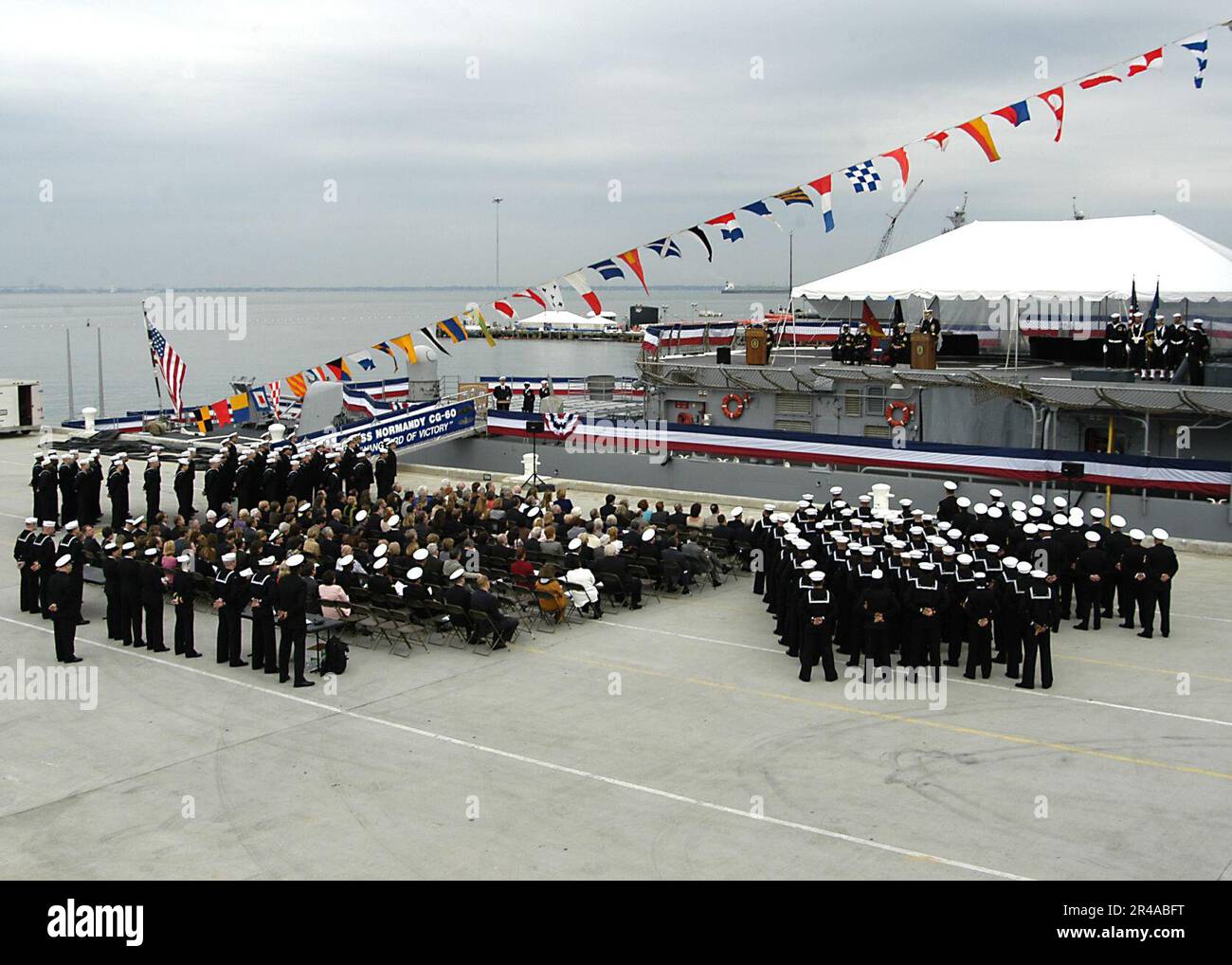 US Navy Crew members, distinguished guests and family members listen to ...