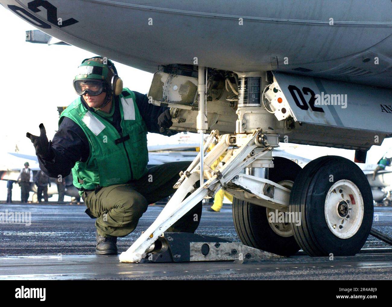 US Navy A Sailor assigned to V-2 Division guides the launch bar into ...