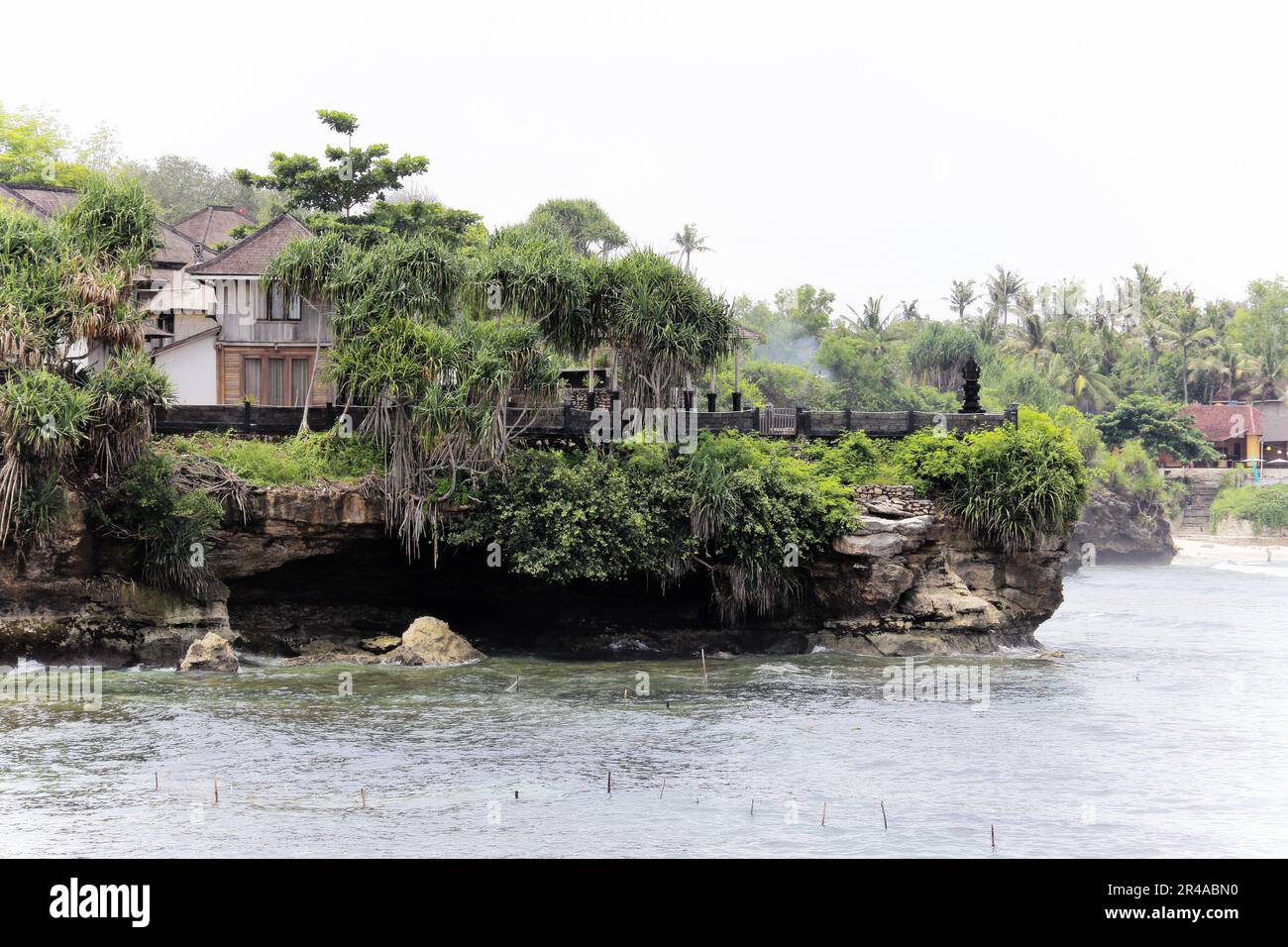 A wooden structure on an island surrounded by lush greenery in a body ...