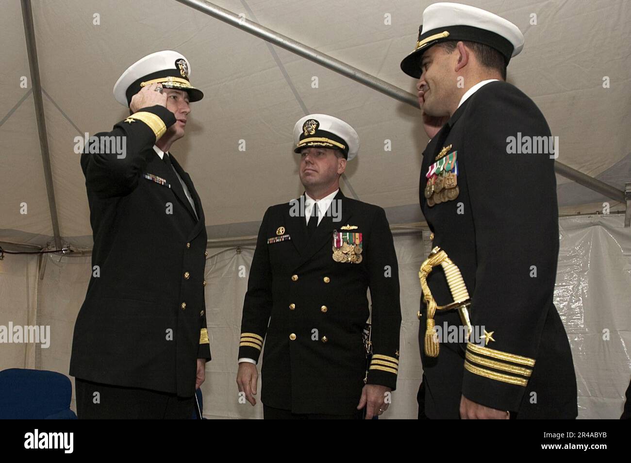 US Navy Cmdr. Timothy B. Spratto, right, renders a hand salute to ...