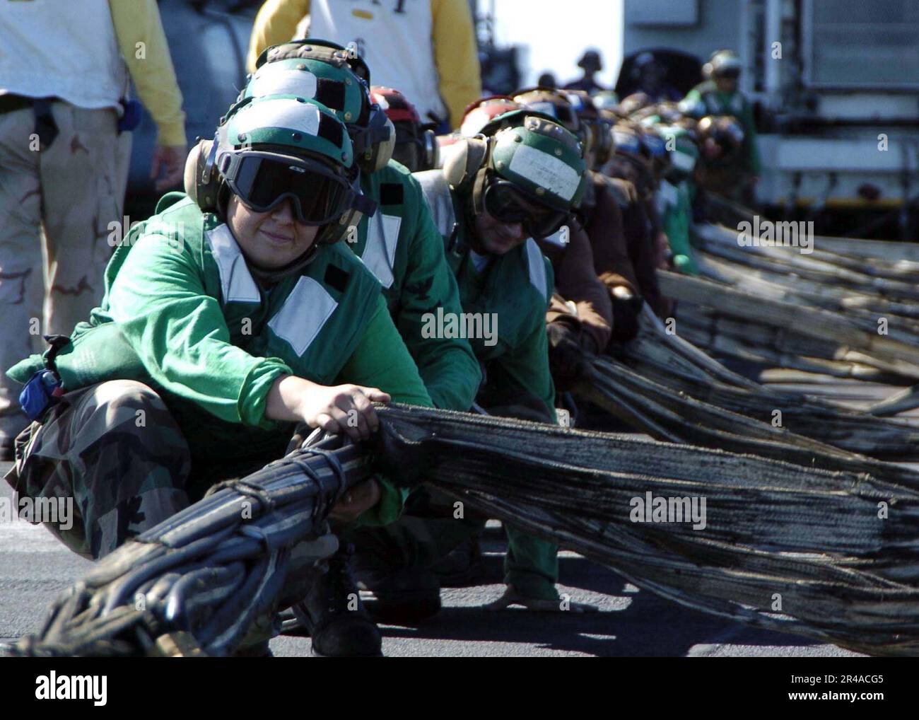 US Navy Flight deck personnel rig the emergency-landing barricade ...