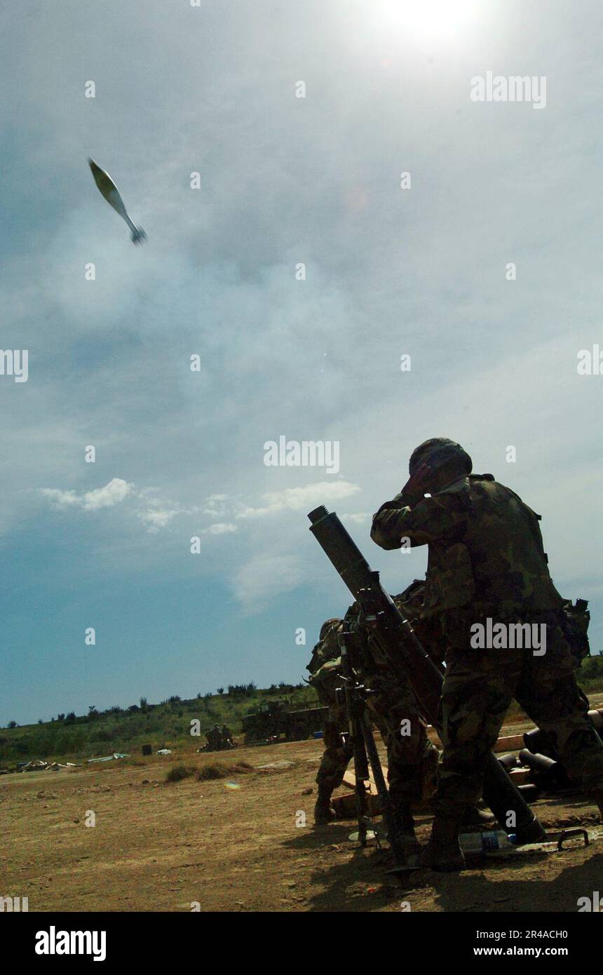 US Navy Sgt. (front), Spc. Squad Leader, and Staff Sgt. fire a mortar ...
