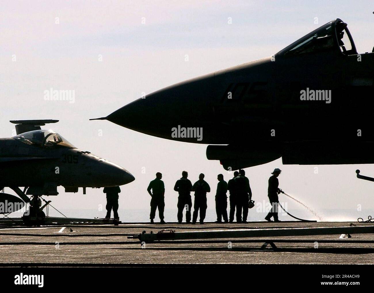 US Navy Flight deck personnel wash the flight deck on the fantail ...