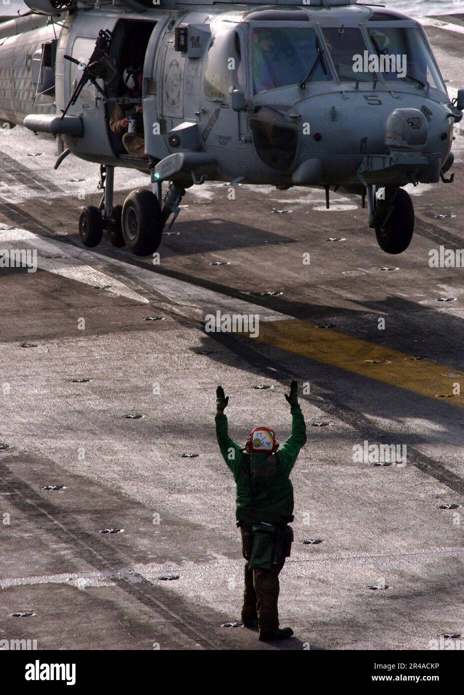 US Navy A Landing Signal Enlisted (LSE) communicates with the pilot of ...
