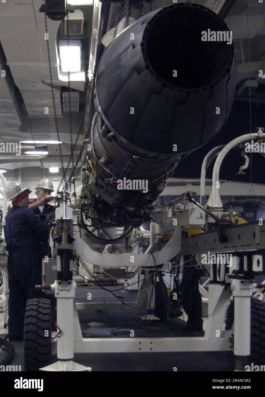 US Navy Sailors perform maintenance on an F-A-18 Hornet engine in the ...