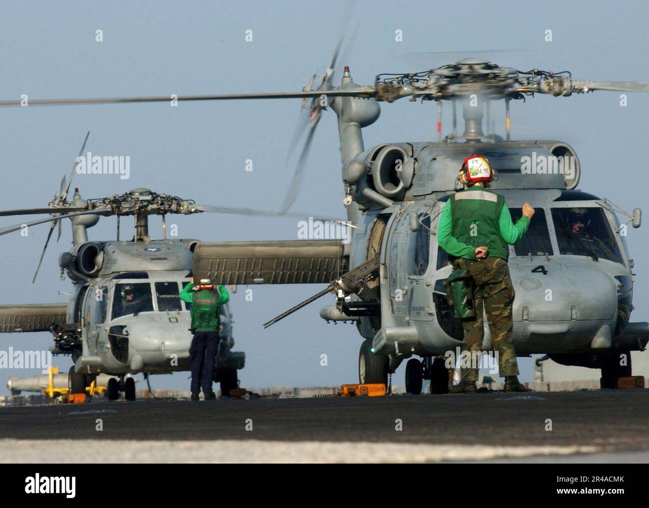 US Navy Two HH-60H Seahawk helicopters prepare to take off from the flight deck of USS Harry S ...