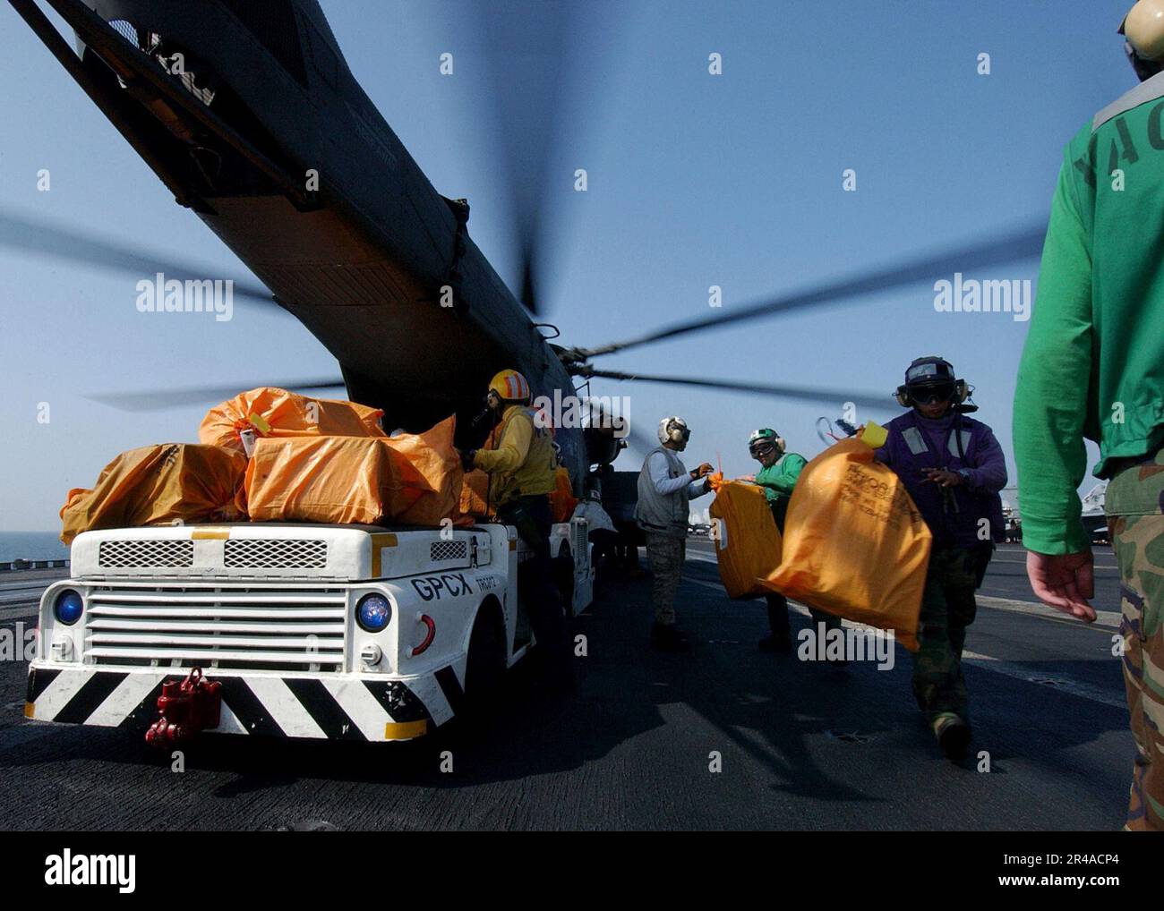 US Navy Crew members unload thousands of pounds of mail from the cargo ...