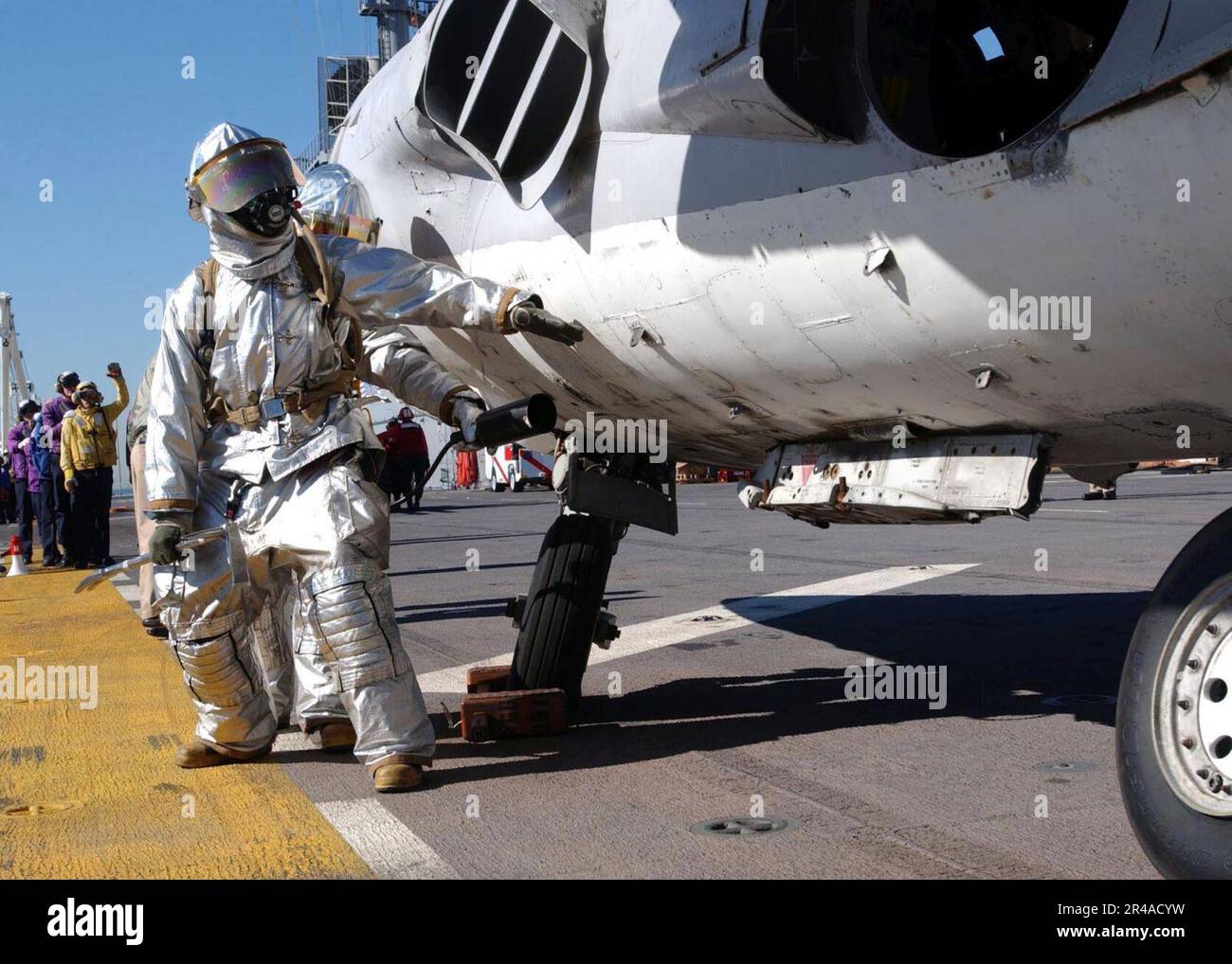 US Navy Crash and salvage personnel check for hot spots on an aircraft ...