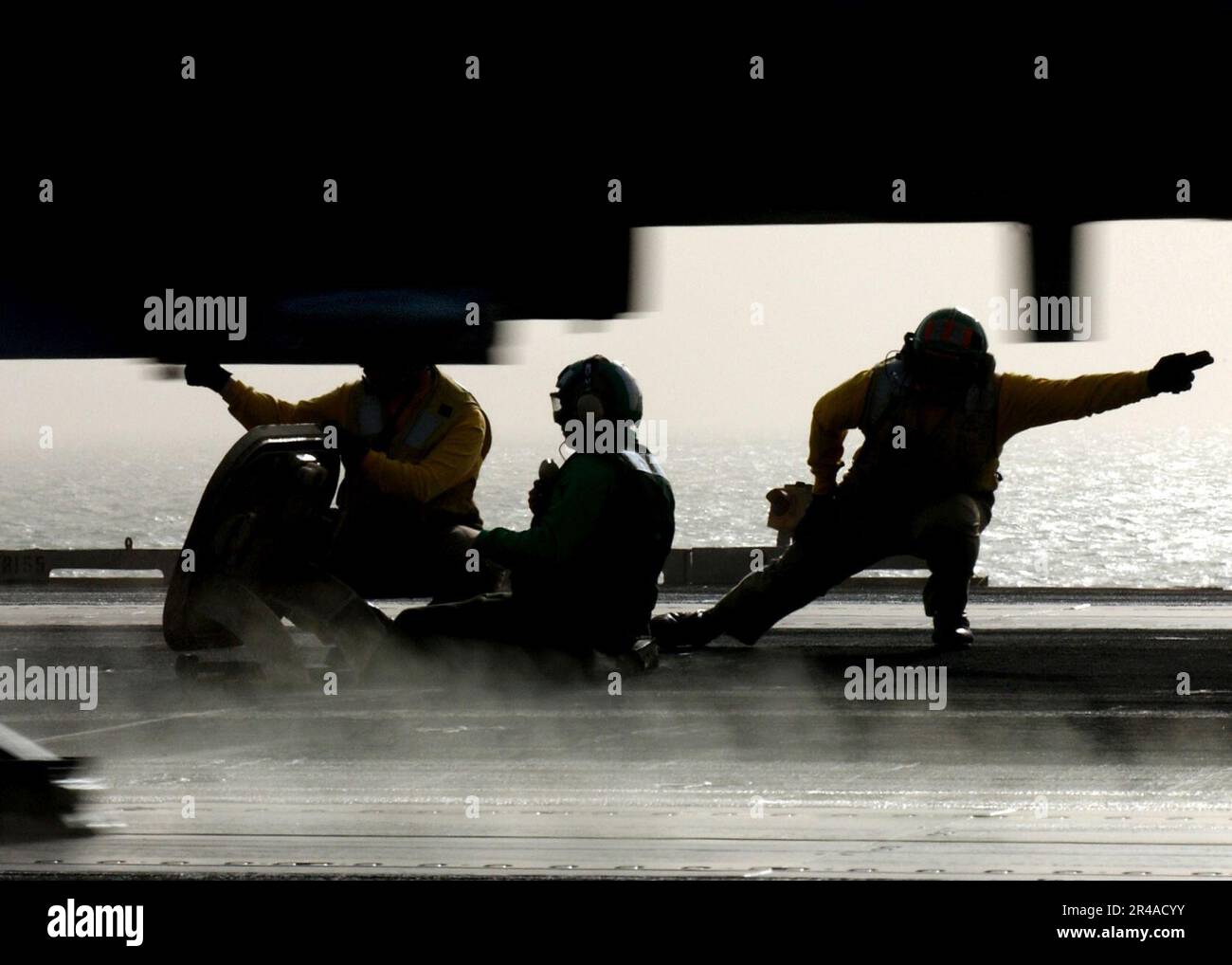 US Navy A catapult shooter holds his position while an F-A-18 Hornet ...