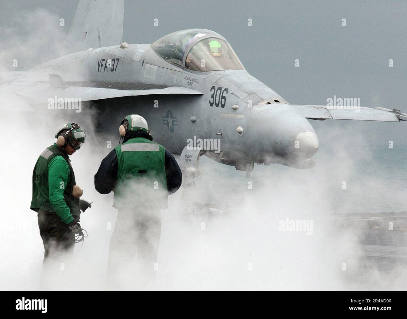 US Navy Flight deck personnel are surrounded by steam escaping from the ...