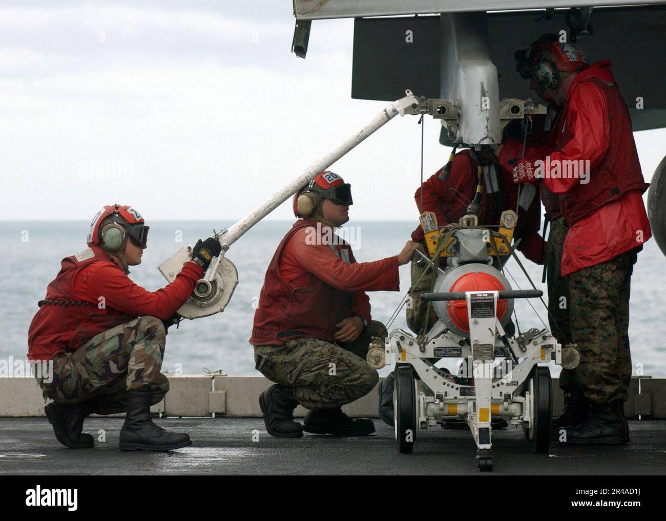 US Navy U.S. Marines Corps Ordnancemen hoist an AGM-65 Maverick laser ...