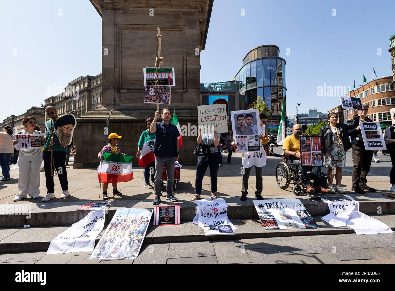 A group of protesters standing in a line in front of a large statue ...
