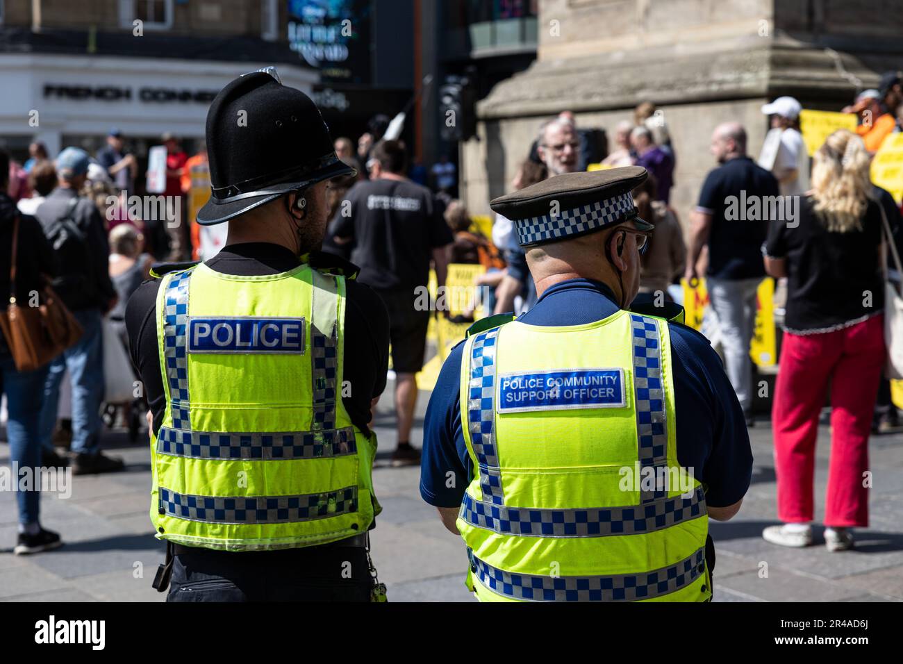 Two law enforcement officers standing on the side of a road in front of ...