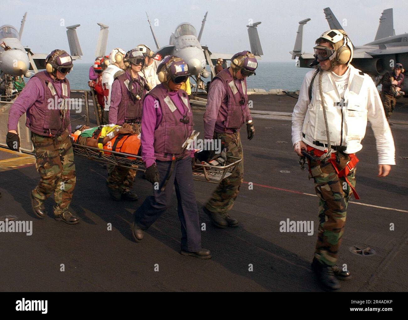 US Navy Sailors help carry an injured shipmate to an MH-53E Sea Dragon ...