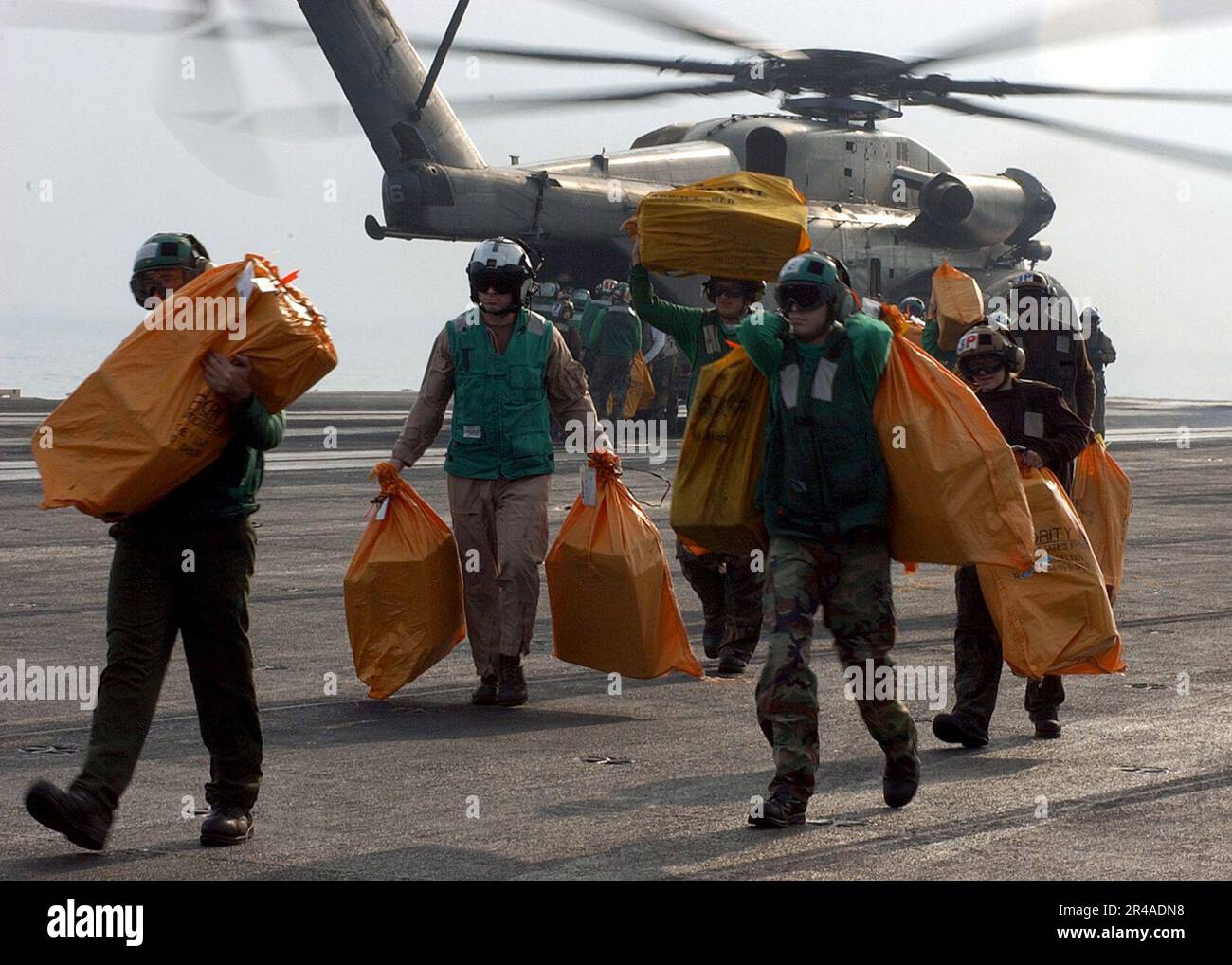 US Navy Sailors unload mail from a MH-53E Sea Dragon assigned to the ...