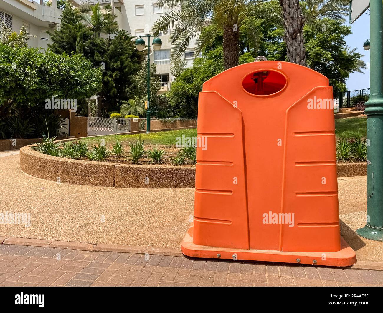 Orange garbage container on city street Stock Photo - Alamy