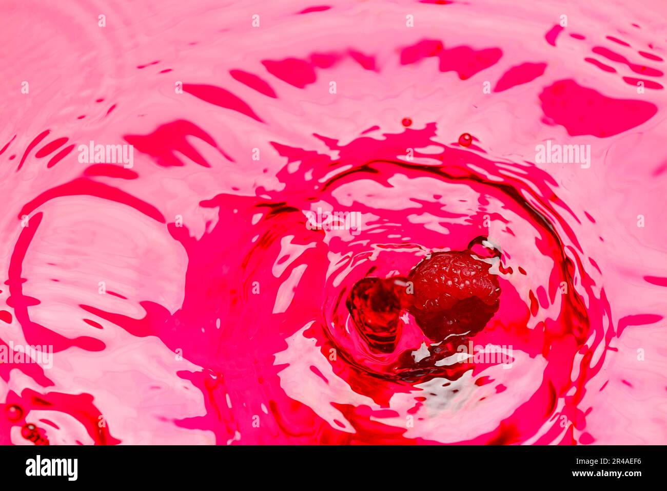 Falling of ripe raspberry into red juice Stock Photo - Alamy