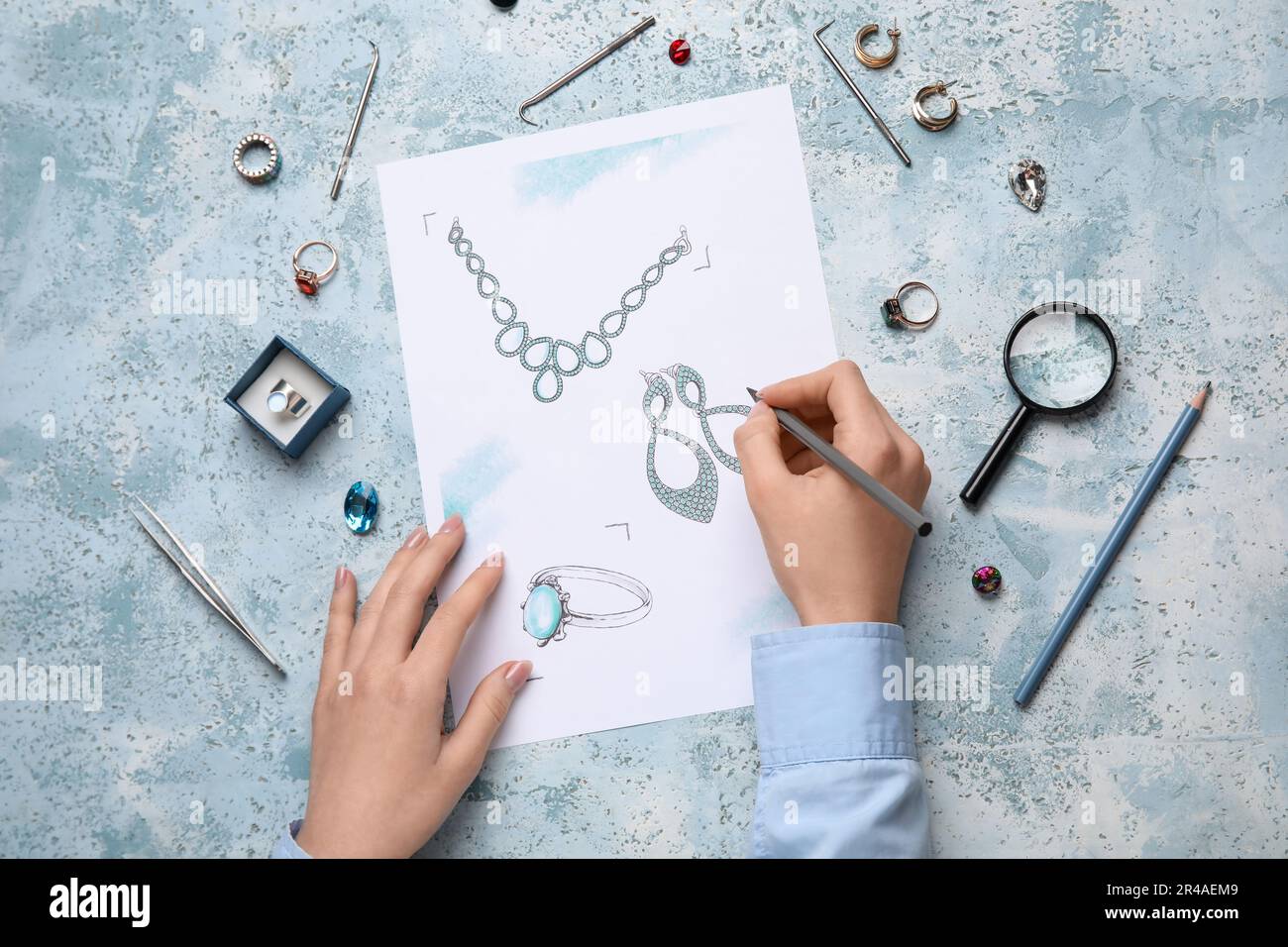 Female jeweler drawing adornment on grunge table, top view Stock Photo ...