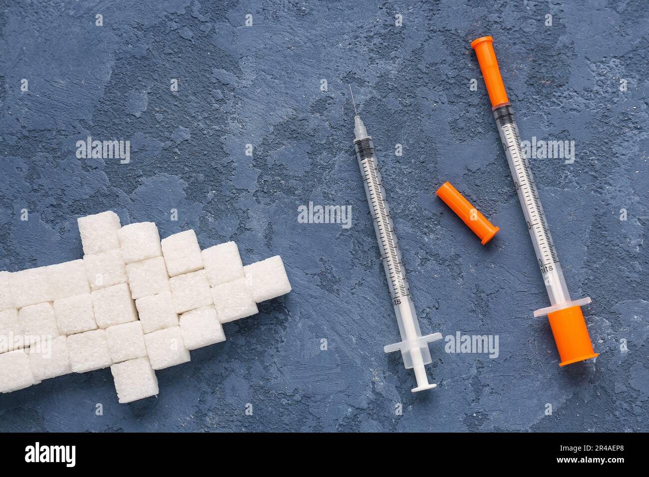 Arrow made of sugar with syringes for insulin injection on dark ...