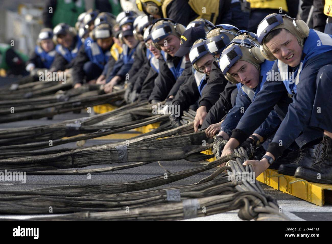 US Navy Flight deck personnel position the aircraft barricade on the ...