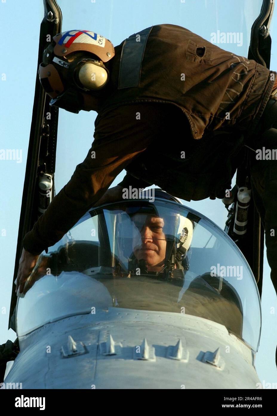 US Navy A plane captain wipes down the windscreen of an F-A-18A- Hornet ...
