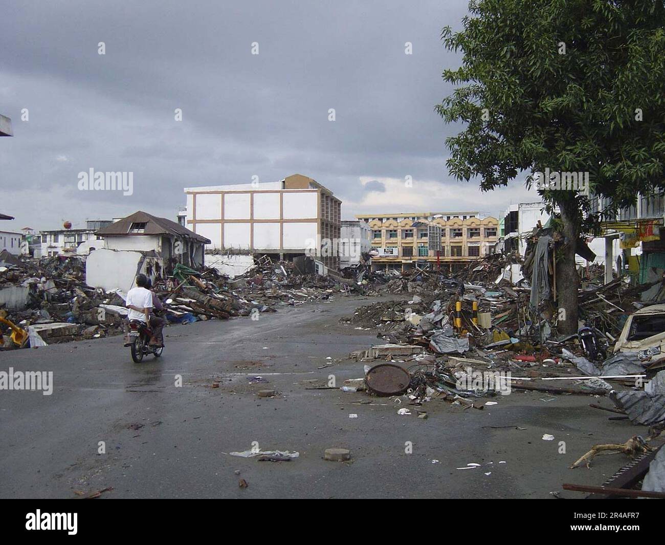 US Navy Trash and debris line the streets while locals check on the ...