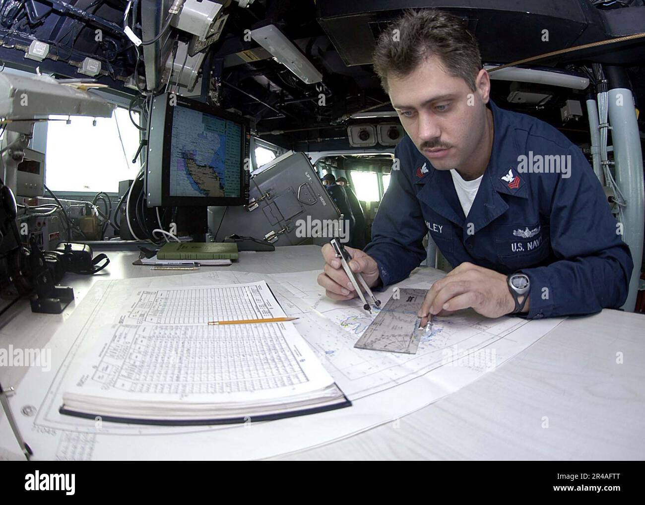 US Navy Quartermaster 1st class prepare charts for a transit through ...