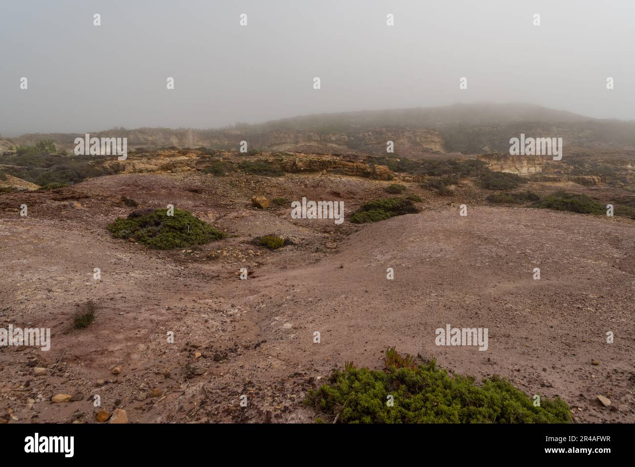A barren desert landscape situated on the edge of a steep cliff ...