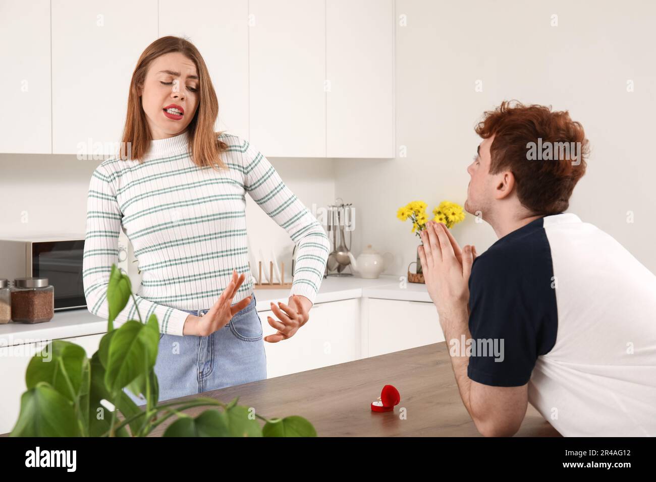 Young woman rejecting marriage proposal in kitchen Stock Photo - Alamy