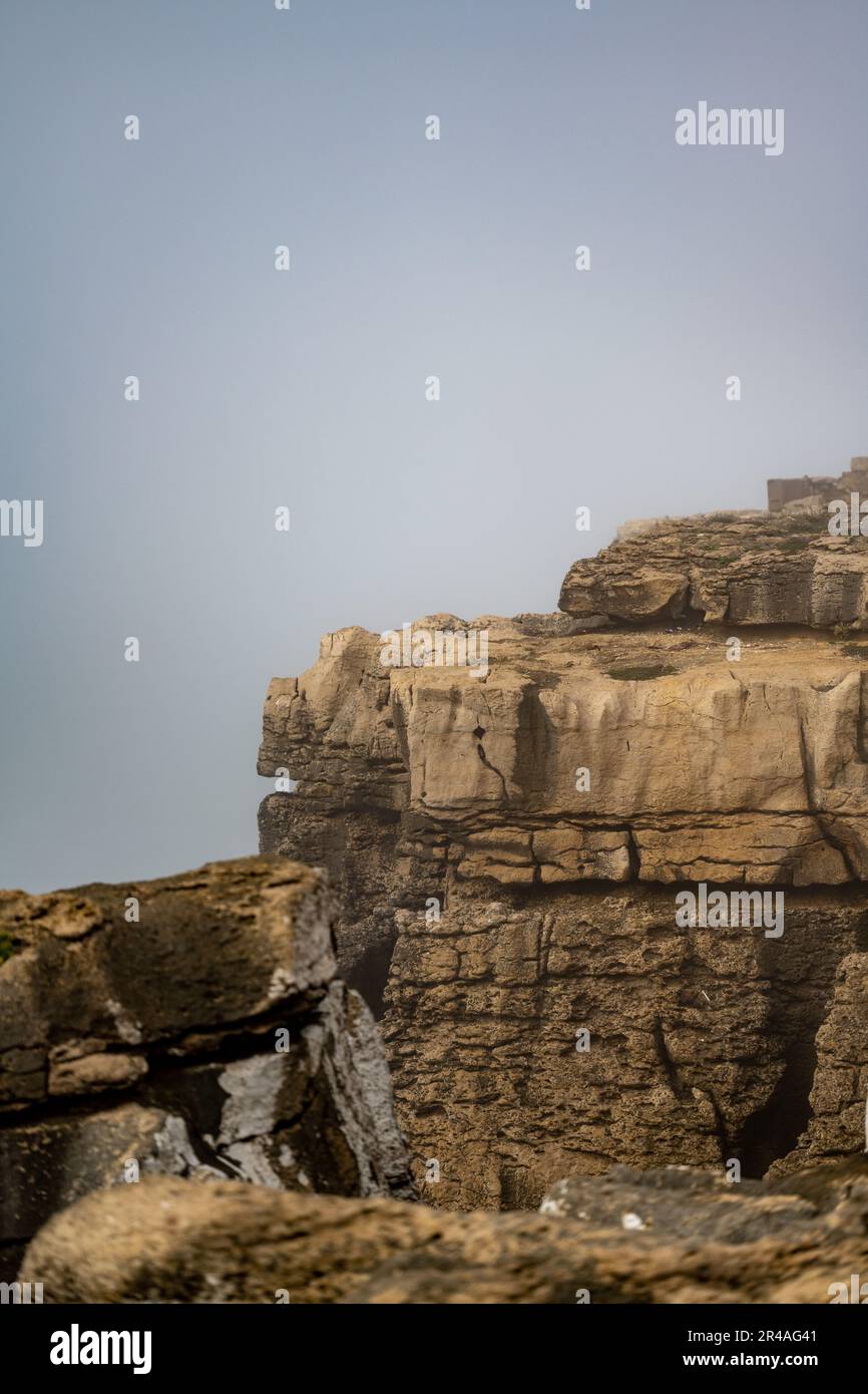 A barren desert landscape situated on the edge of a steep cliff ...