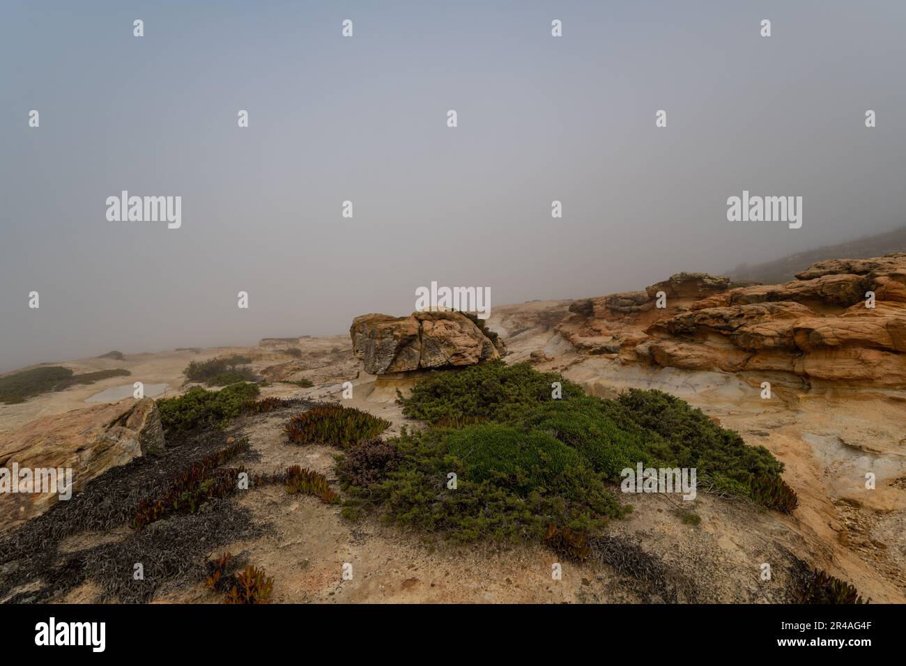 A barren desert landscape situated on the edge of a steep cliff ...