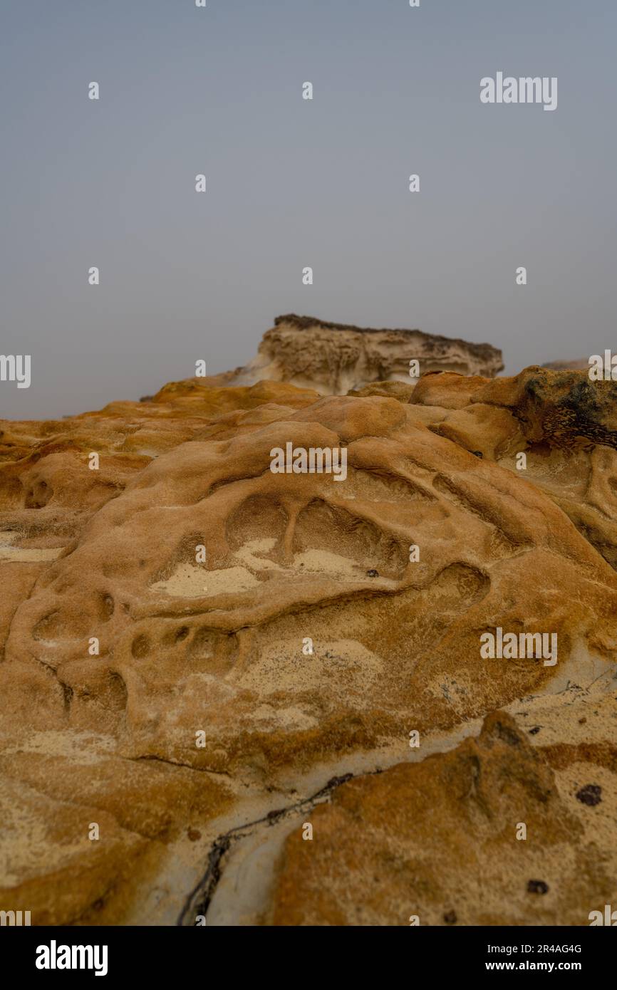 A barren desert landscape situated on the edge of a steep cliff ...