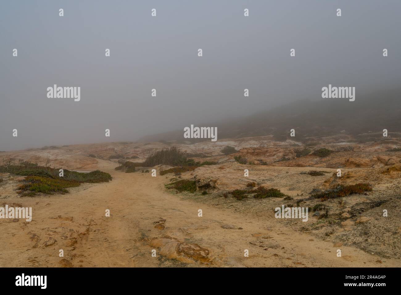 A barren desert landscape situated on the edge of a steep cliff ...