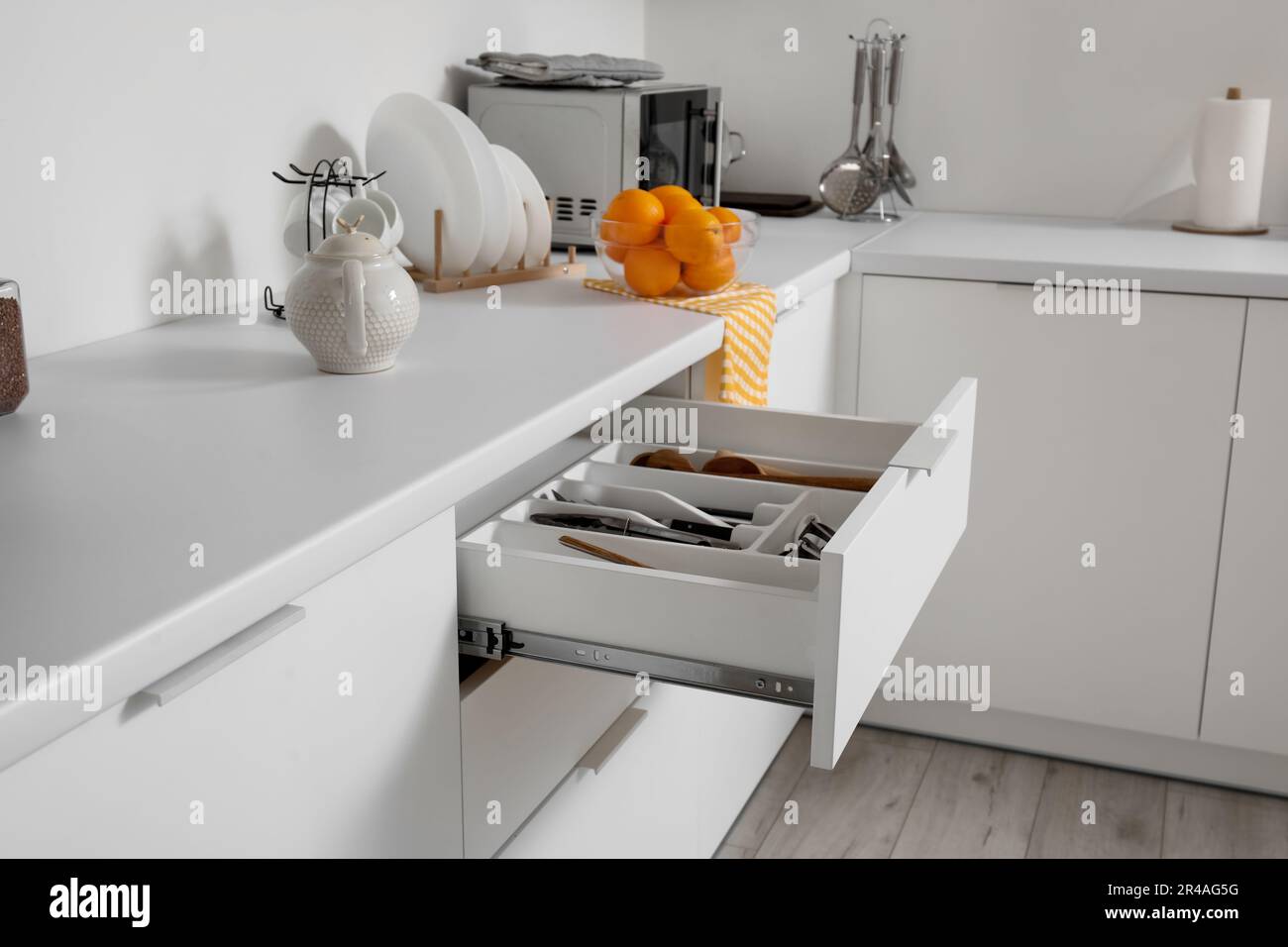 Open drawers with utensils in light kitchen Stock Photo - Alamy