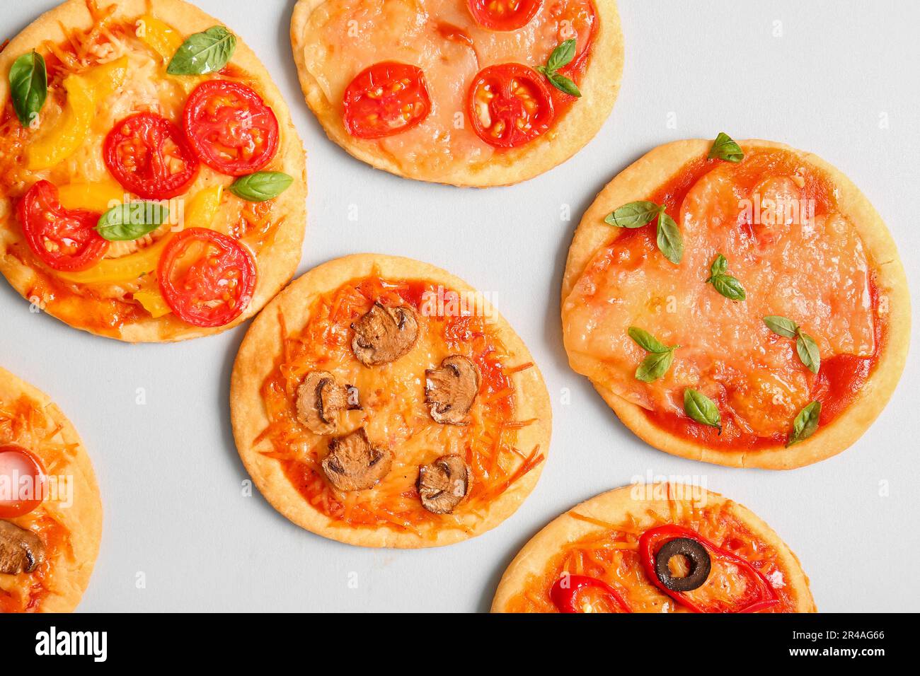 Different tasty mini pizzas on grey background Stock Photo - Alamy