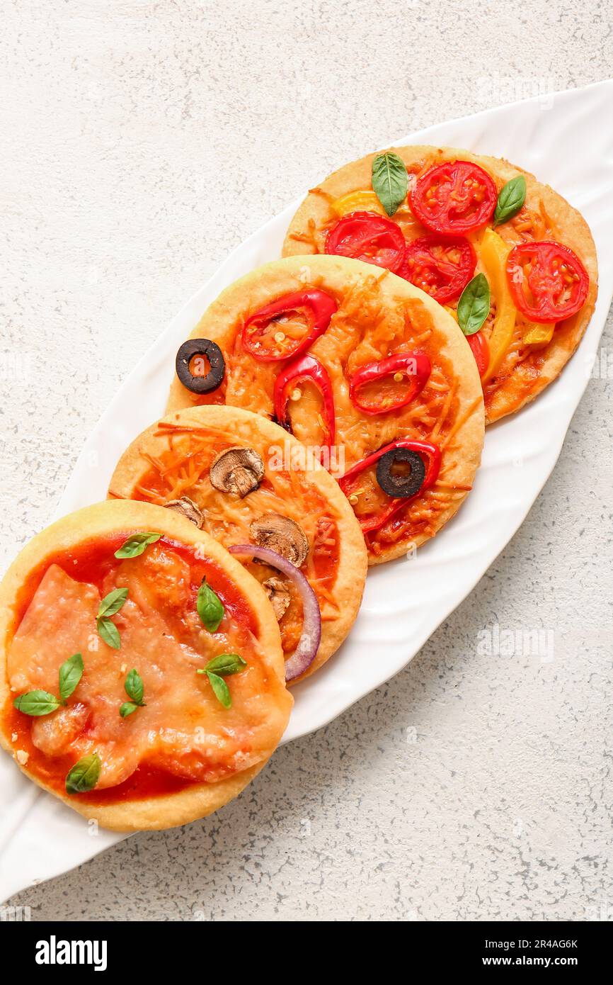 Plate with different tasty mini pizzas on white background Stock Photo ...
