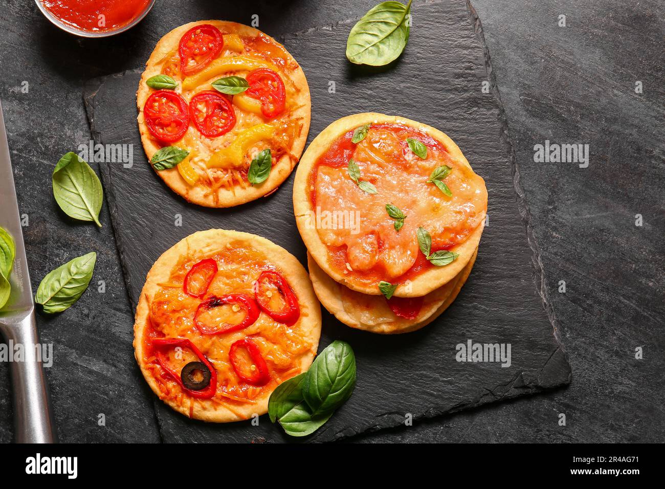 Board with different tasty mini pizzas on black background Stock Photo ...