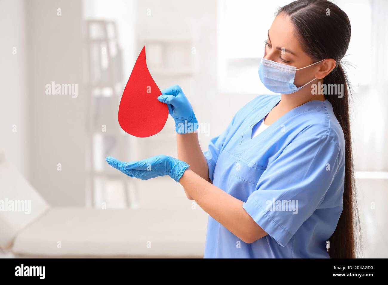 Female nurse with paper blood drop in clinic Stock Photo - Alamy
