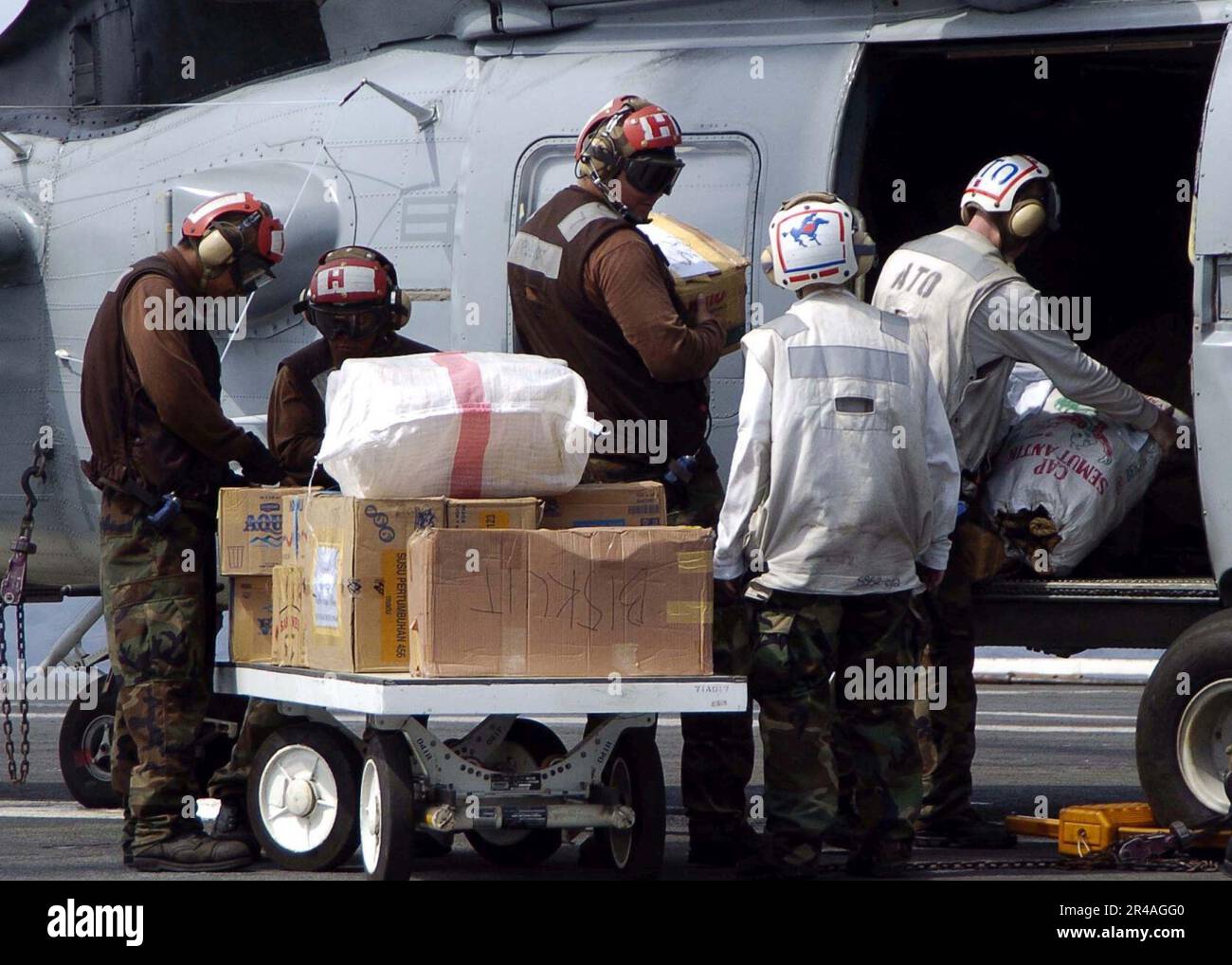 US Navy Boxes of water and food are loaded onto a SH-60B Seahawk ...